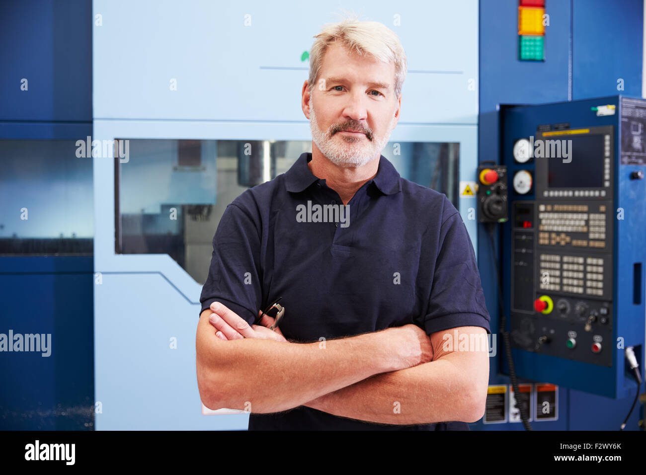 Portrait Of Male Engineer Operating CNC Machinery In Factory Stock ...
