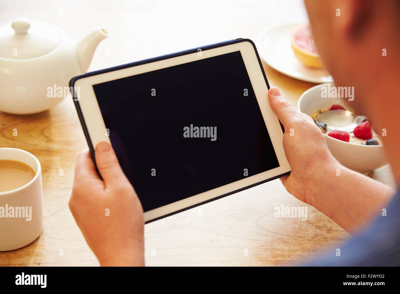Person Looking At Digital Tablet Whilst Eating Breakfast Stock Photo ...