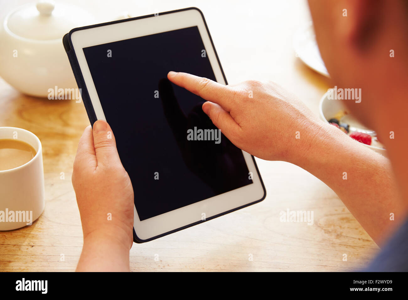 Person Looking At Digital Tablet Whilst Eating Breakfast Stock Photo ...