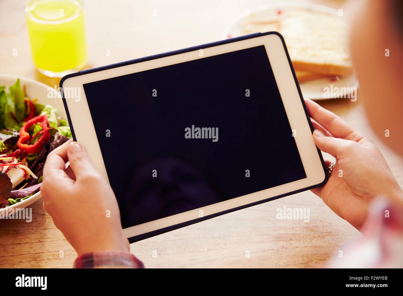 Person Looking At Digital Tablet Whilst Eating Lunch Stock Photo - Alamy