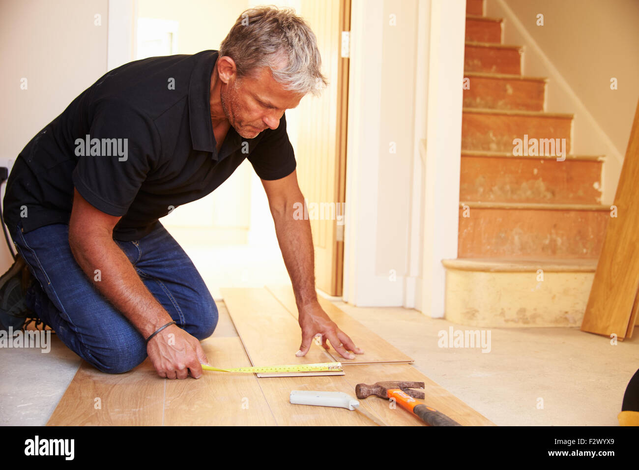 Man laying wood panel flooring during a house refurbishment Stock Photo ...