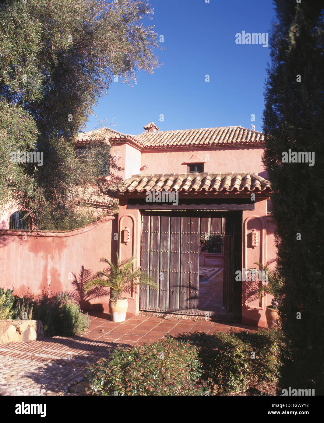 Exterior of traditional Spanish villa with rustic wooden gates below a ...