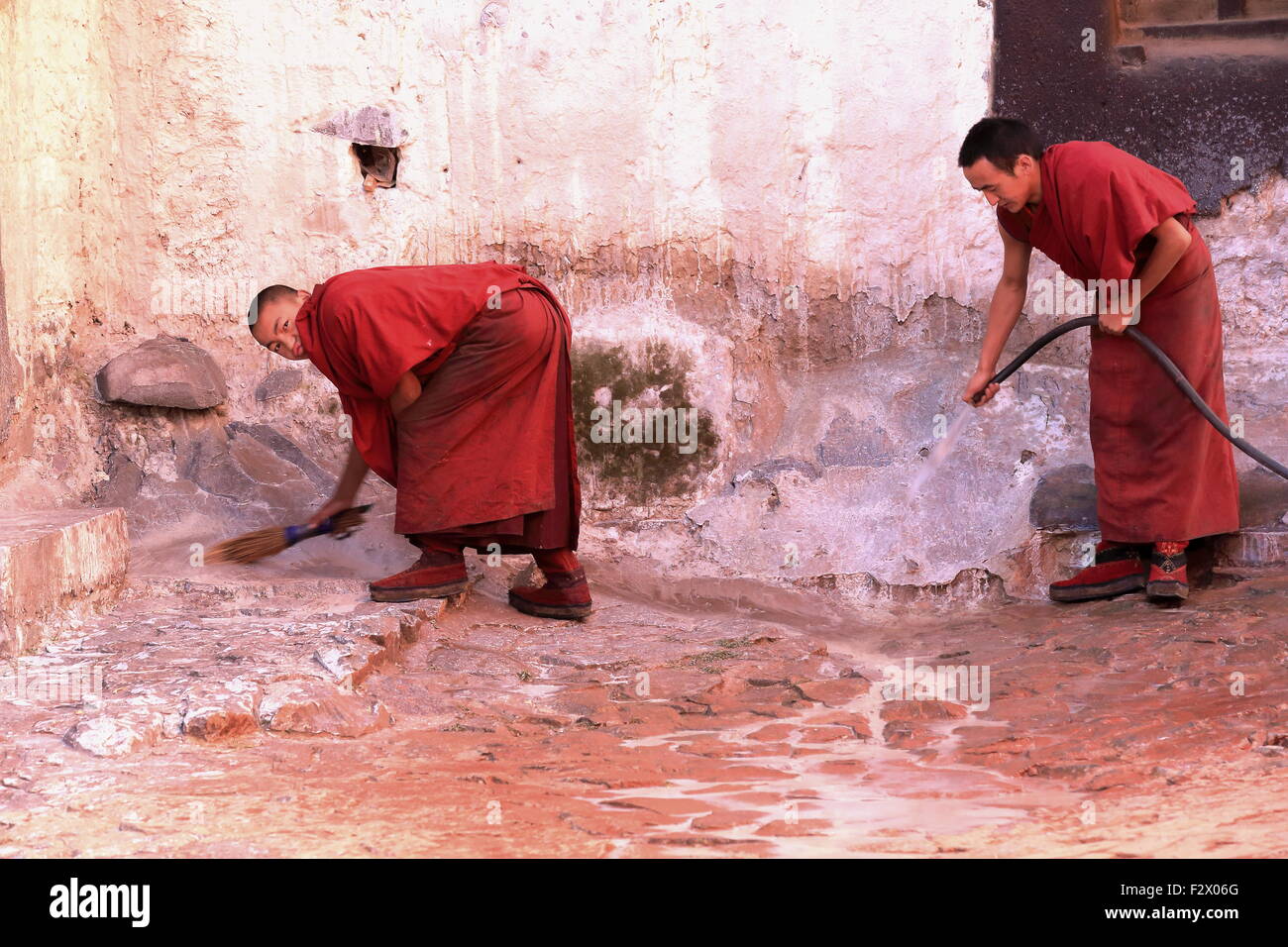 SHIGATSE, TIBET, CHINA-OCTOBER 24: Monks with broom and hose wash the ...