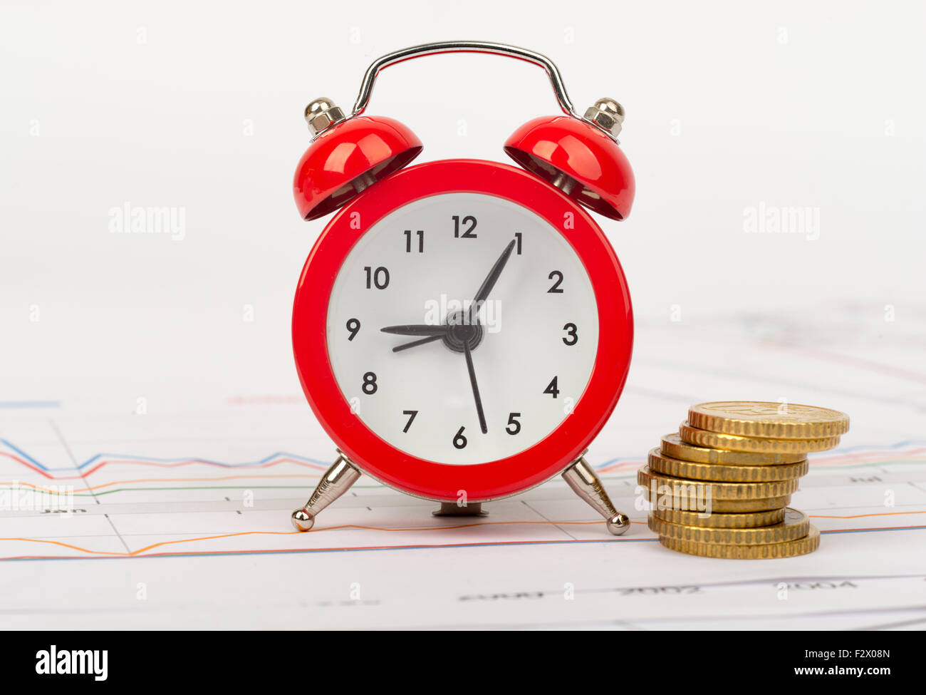 Red alarm clock with coins Stock Photo - Alamy