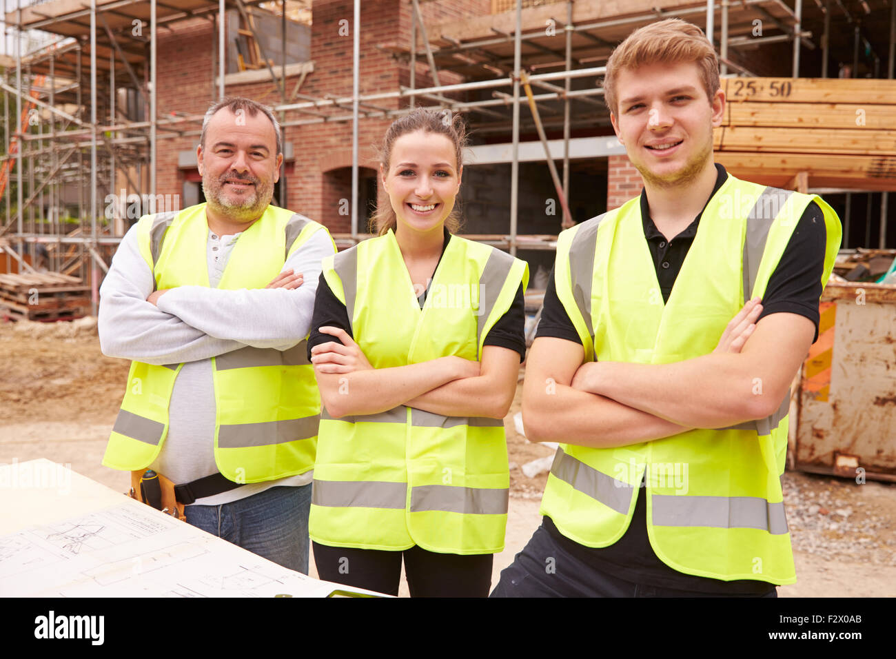 Portrait Of Builder On Building Site With Apprentices Stock Photo - Alamy