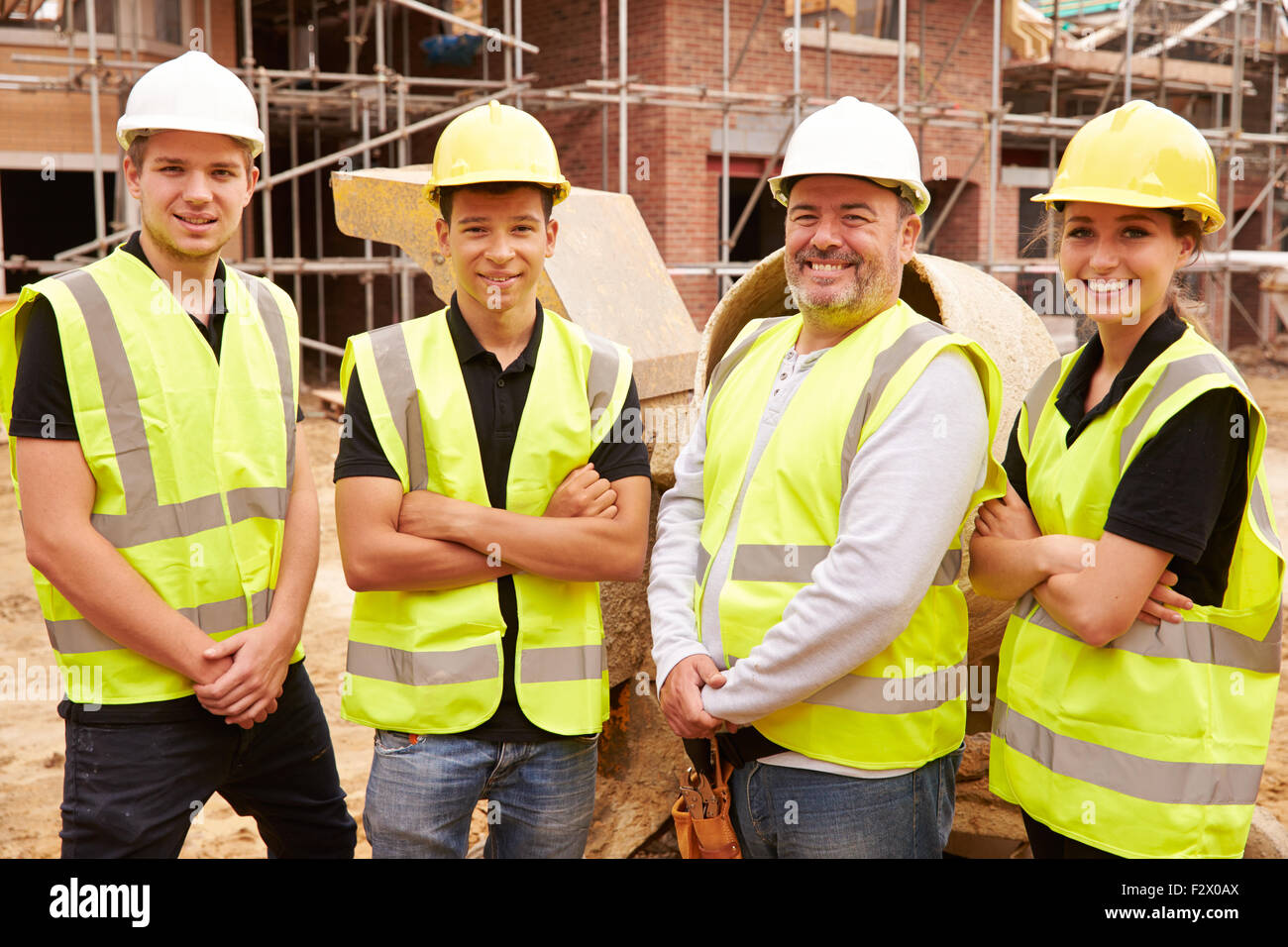Portrait Of Builder On Building Site With Apprentices Stock Photo - Alamy