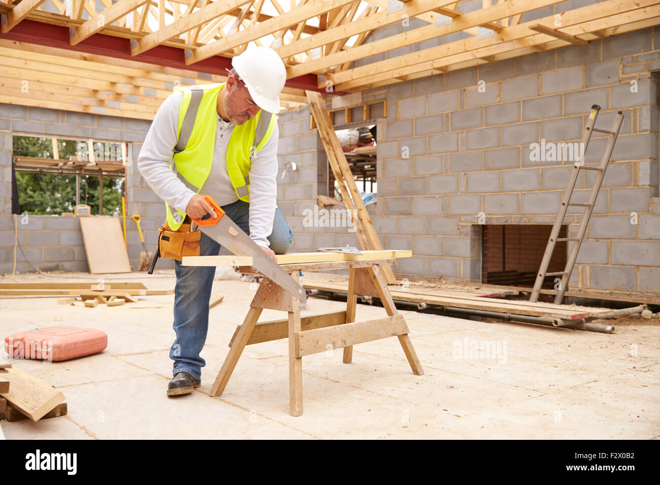 Carpenter Cutting House Roof Supports On Building Site Stock Photo - Alamy