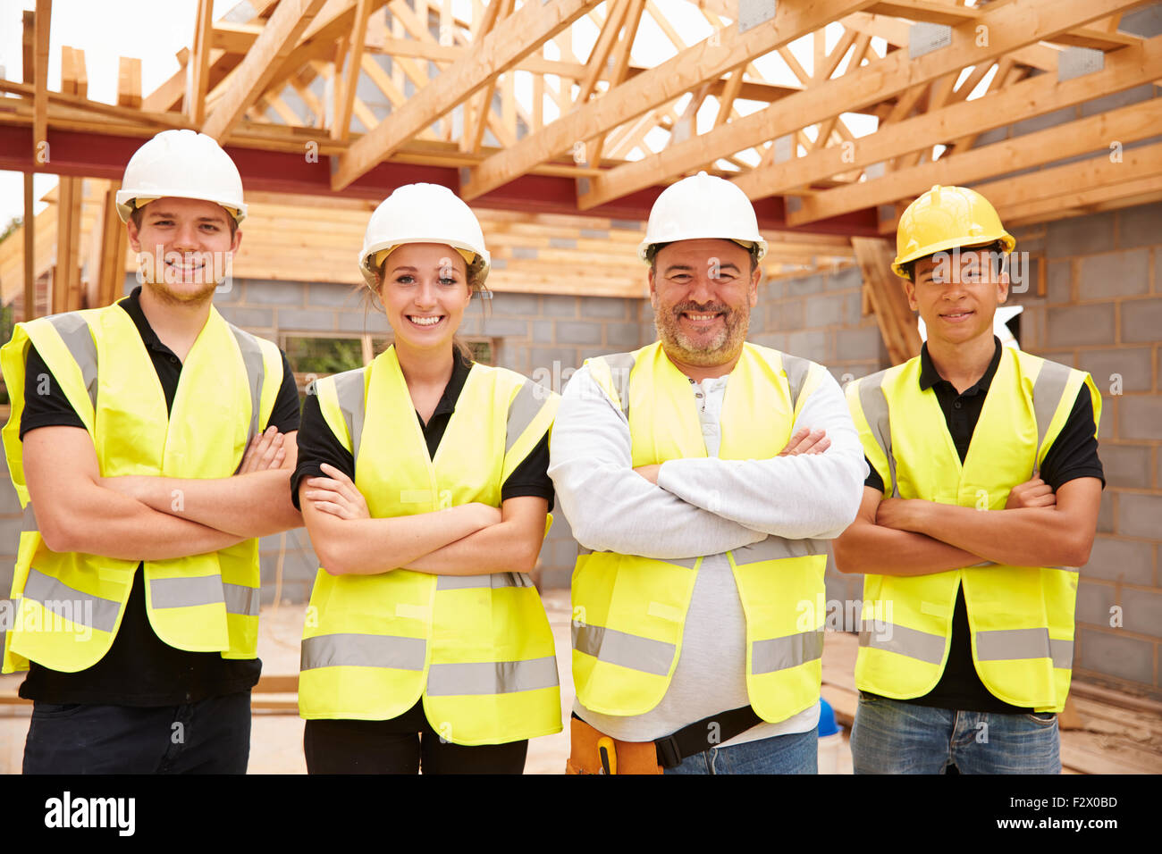 Portrait Of Builder On Building Site With Apprentices Stock Photo - Alamy