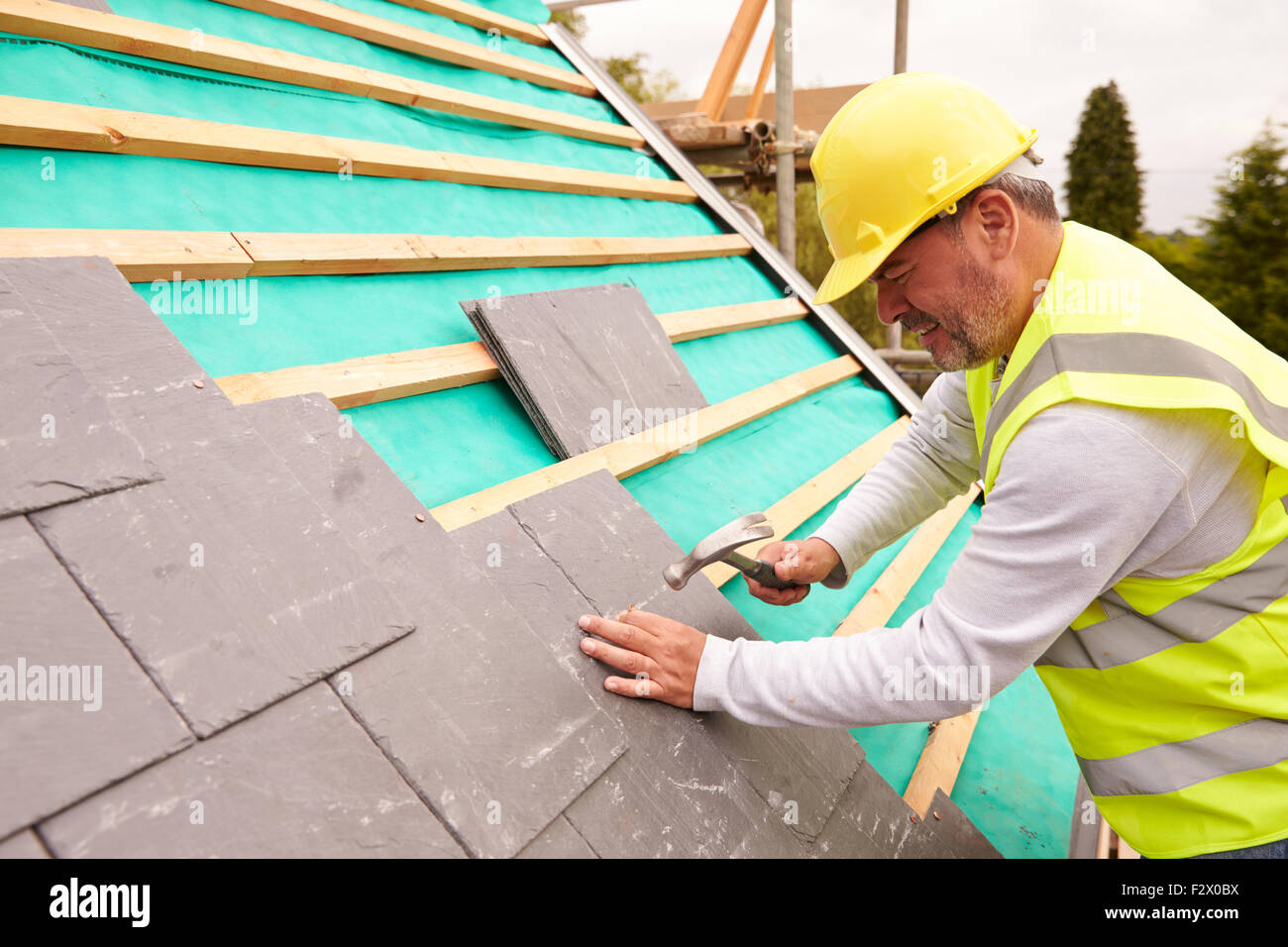 Construction Worker On Building Site Laying Slate Tiles Stock Photo - Alamy