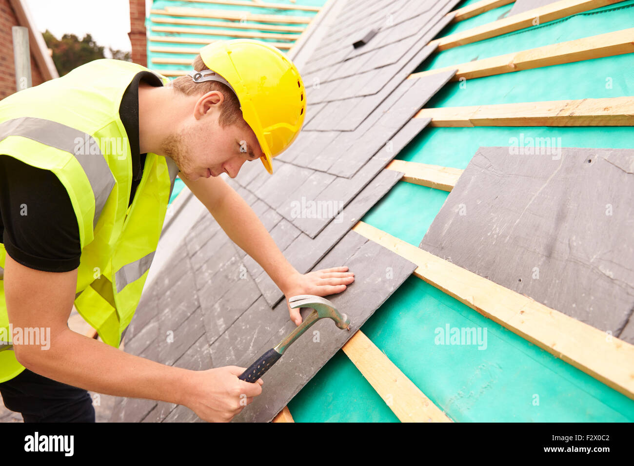 Construction Worker On Building Site Laying Slate Tiles Stock Photo - Alamy