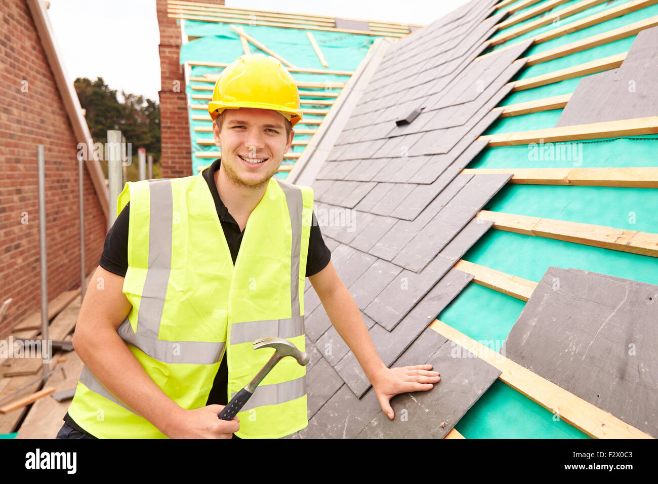 Construction Worker On Building Site Laying Slate Tiles Stock Photo - Alamy