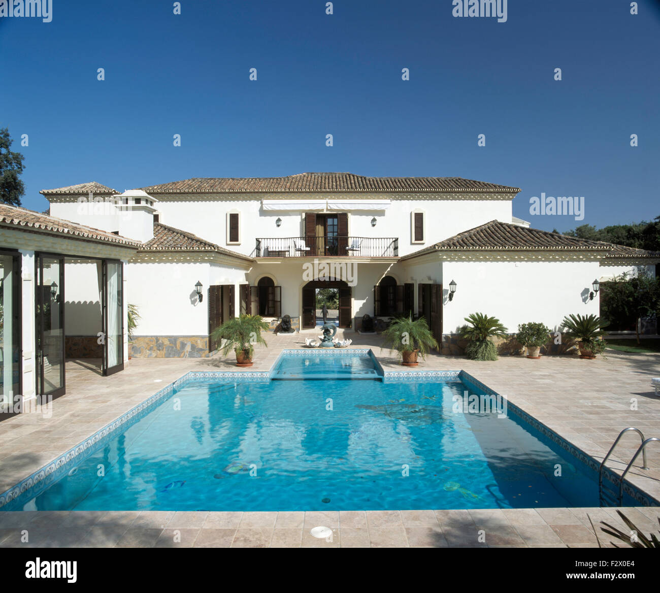 Turquoise swimming pool in front of large Spanish villa Stock Photo - Alamy