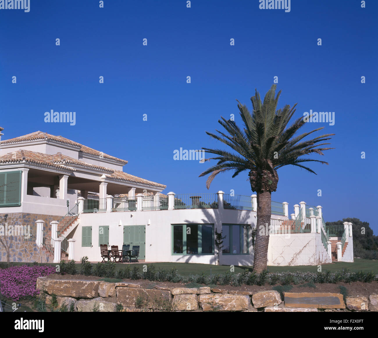 Palm tree beside large Spanish villa Stock Photo - Alamy