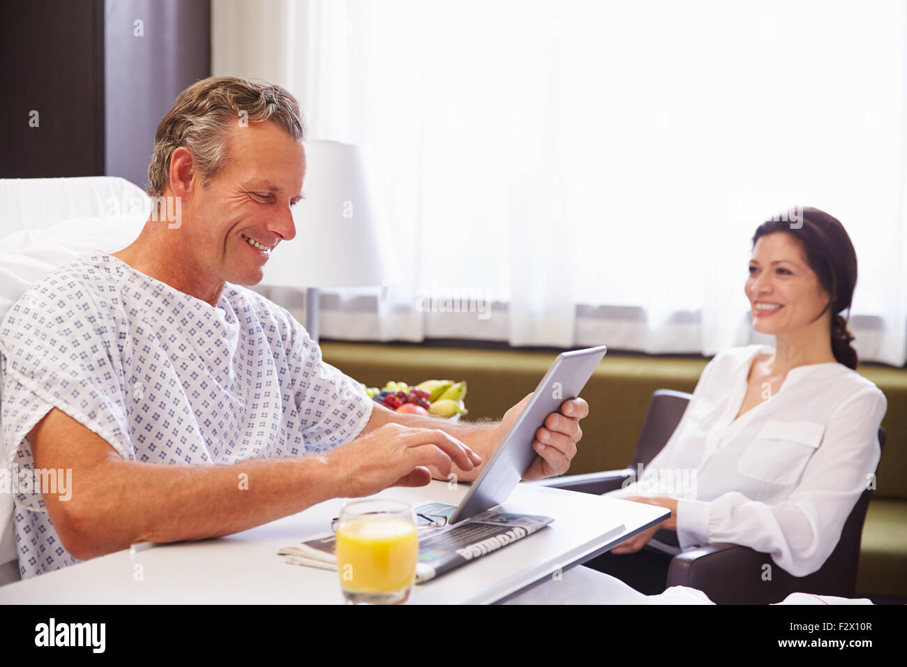 Male Patient In Hospital Bed Using Digital Tablet Stock Photo - Alamy