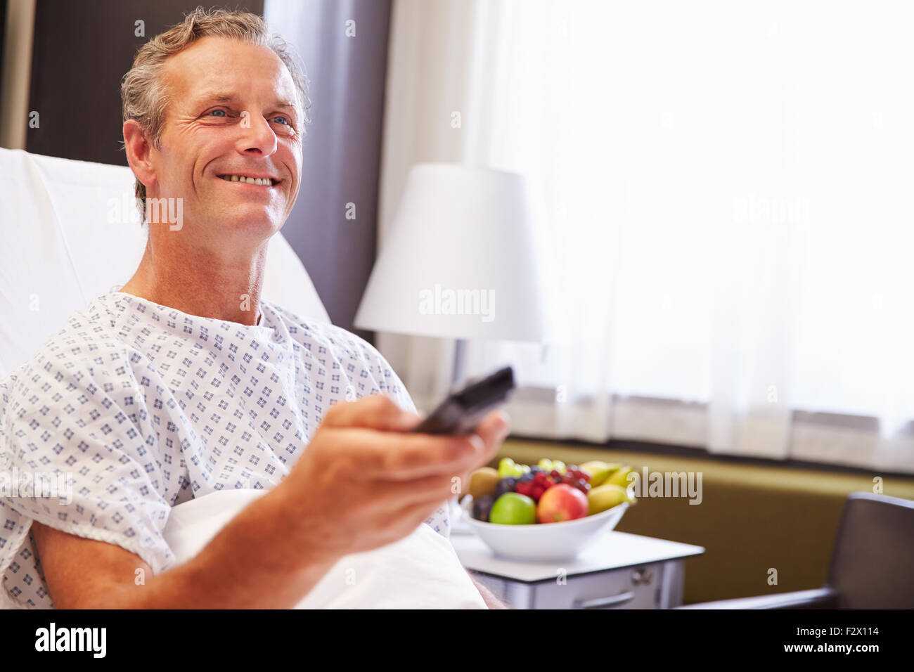 Male Patient In Hospital Bed Watching Television Stock Photo - Alamy