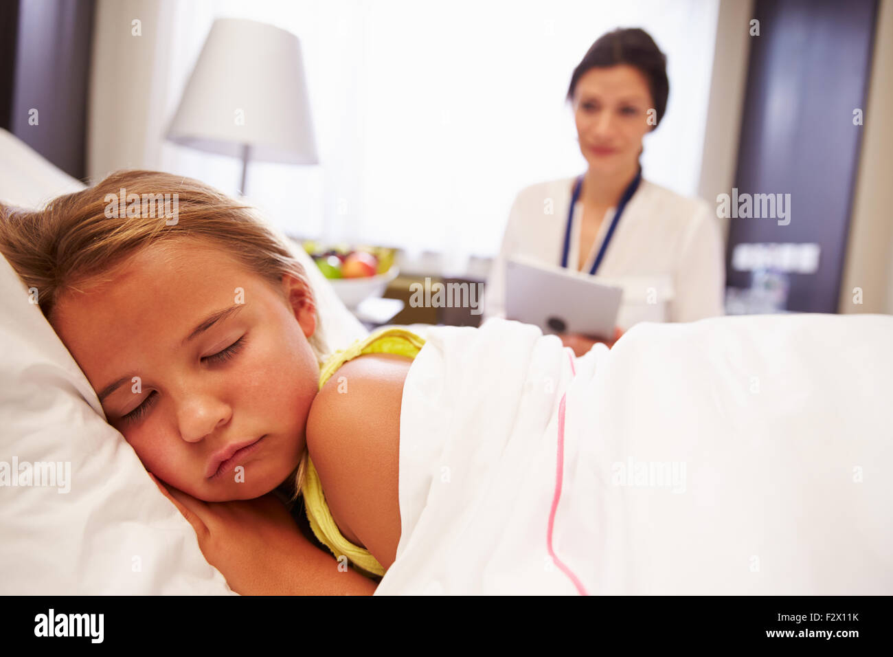 Doctor Observing Sleeping Child Patient In Hospital Bed Stock Photo - Alamy