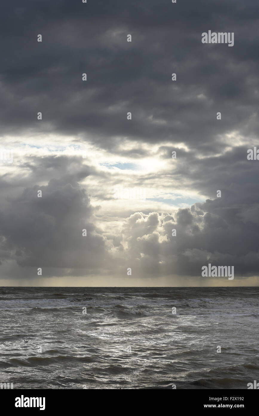 Dramatic clouds with shafts of sunlight and rain over the sea at the ...