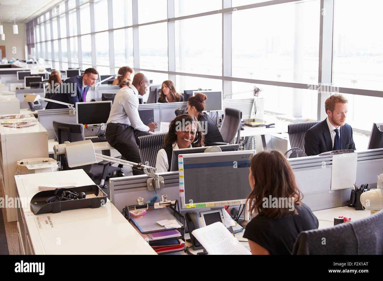 Coworkers at their desks in a busy, open plan office Stock Photo - Alamy