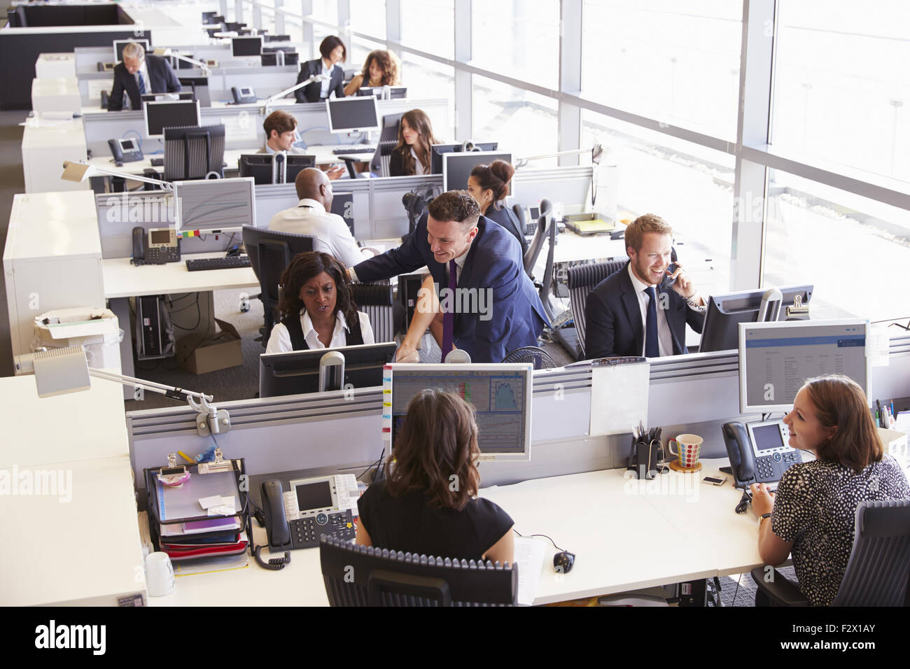 Manager in discussion with coworker in an open plan office Stock Photo ...