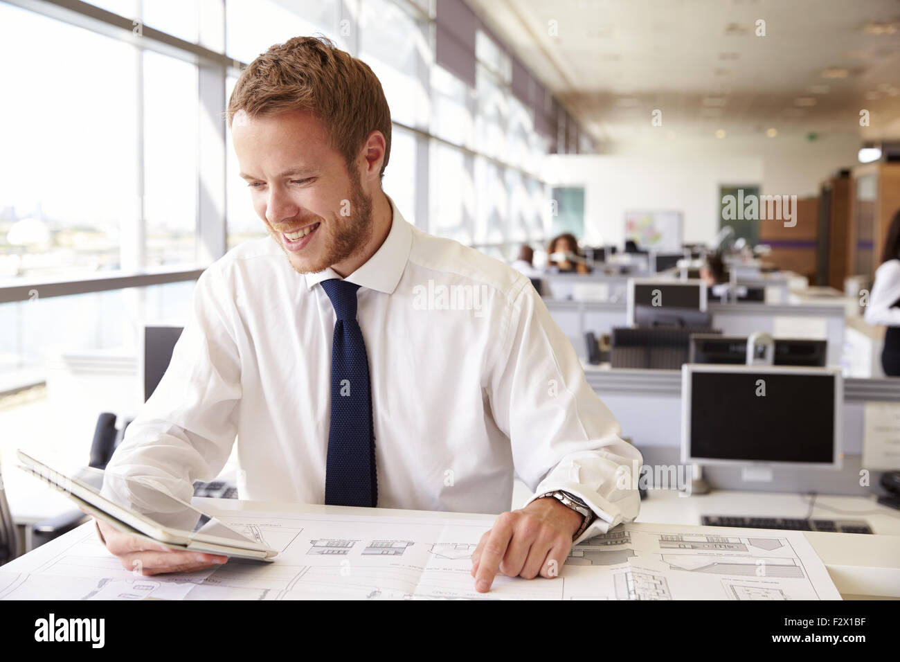 Young architect at work in an office using tablet computer Stock Photo ...