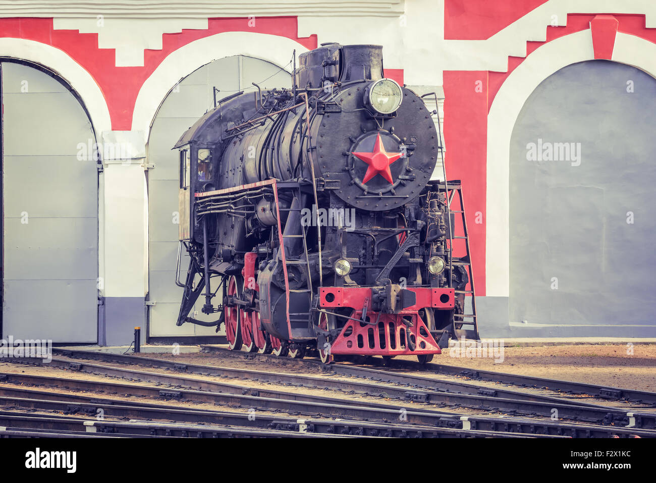 Old retro steam locomotive stands by the gates of the depot Stock Photo ...