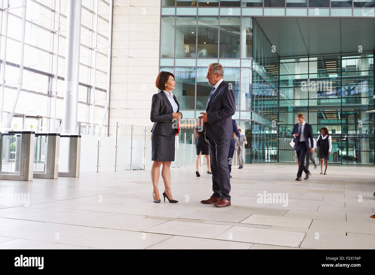 Two senior colleagues talking in the foyer of a big business Stock ...