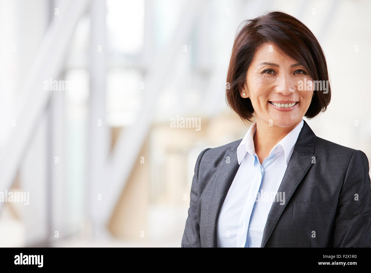 Head and shoulders portrait of smiling Asian businesswoman Stock Photo ...