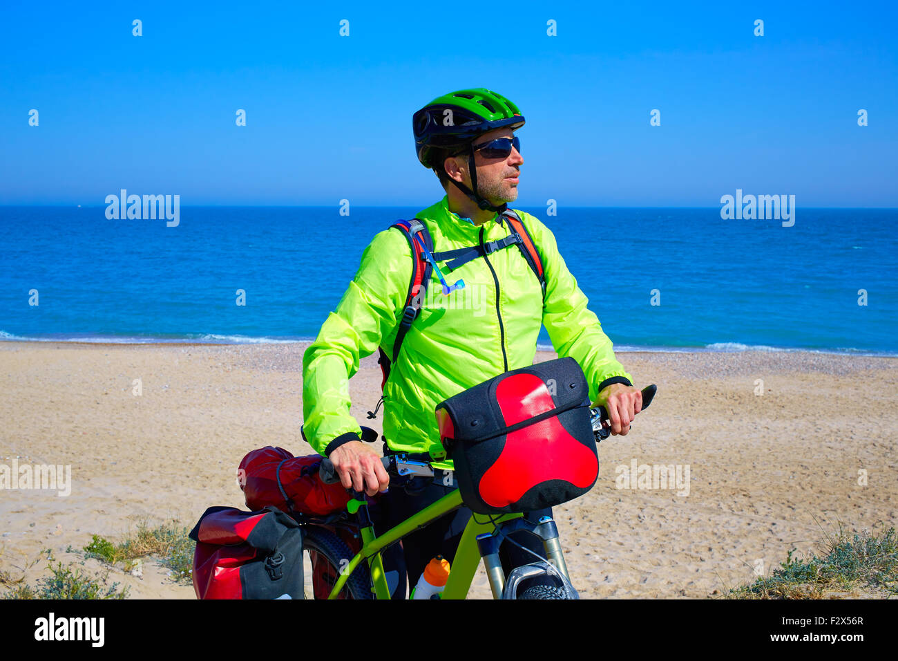 cycling tourist MTB cyclist in Mediterranean beach with paniers and ...