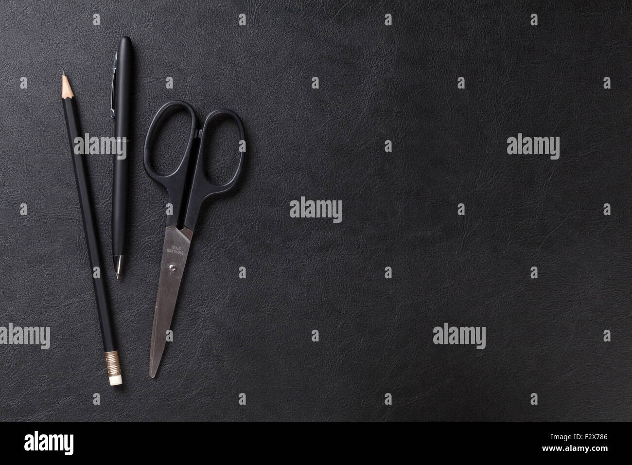 Office leather desk table with pen, pencil and scissors. Top view with ...