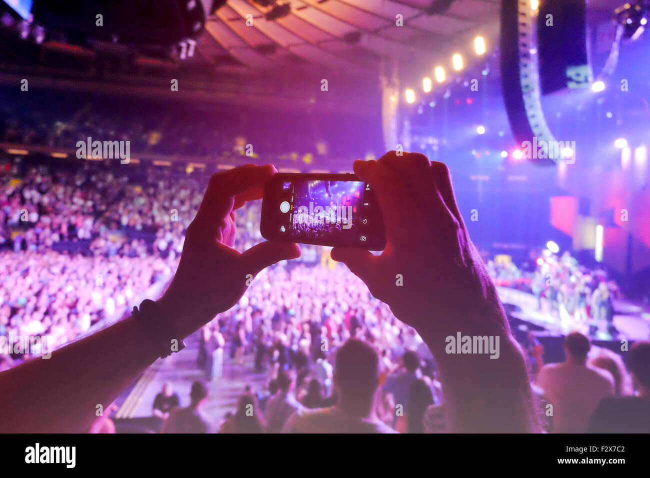 Hands holding smart phone, filming concert Stock Photo - Alamy