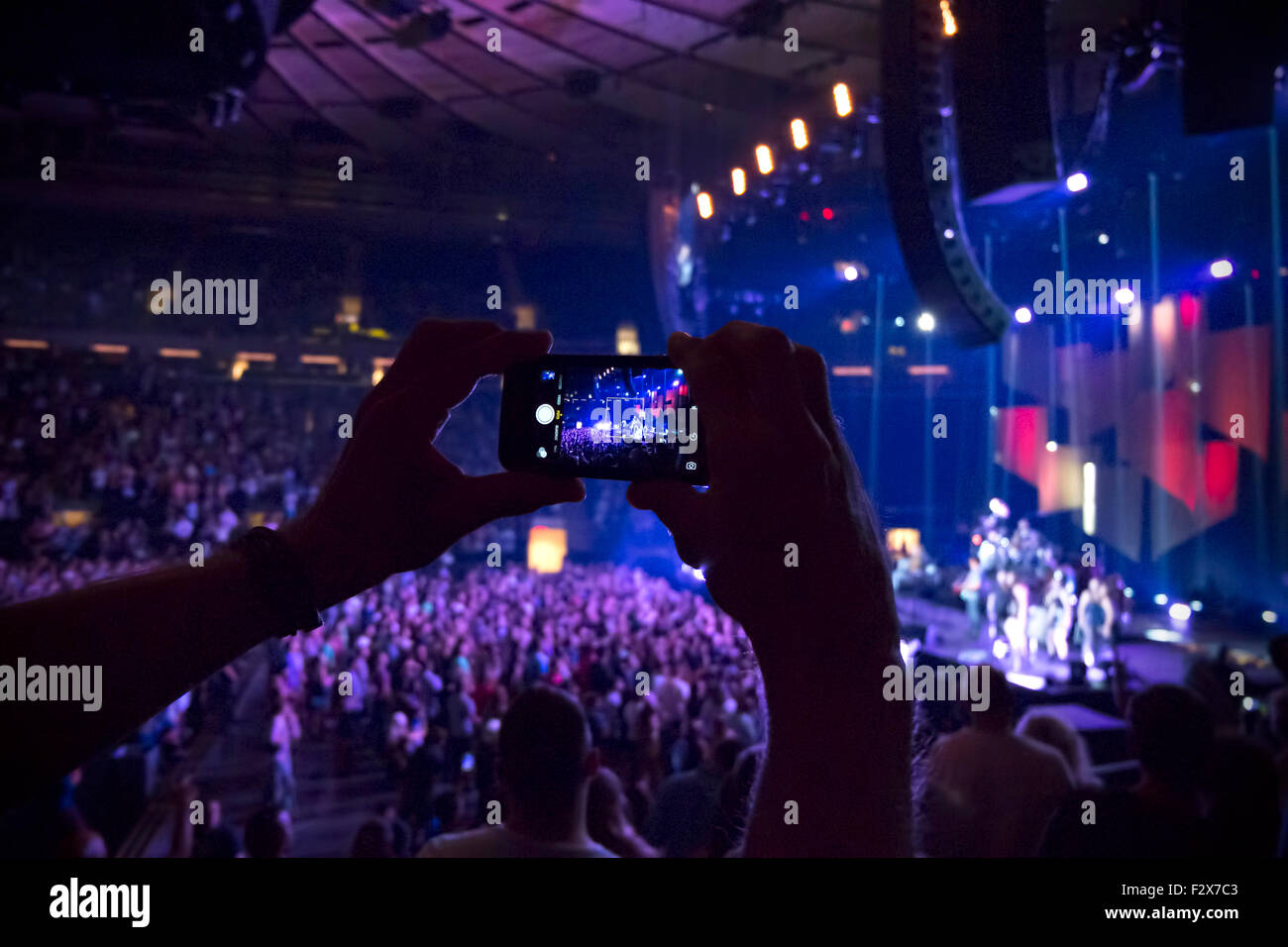 Hands holding smart phone, filming concert Stock Photo - Alamy