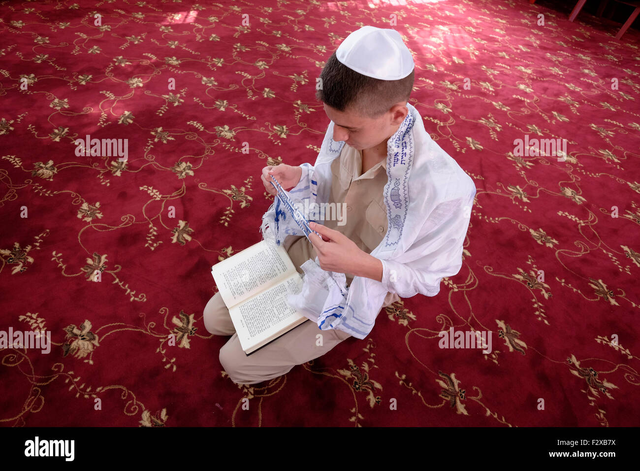 Young uniformed Karaite Jew bowing on the knees during prayer in a ...