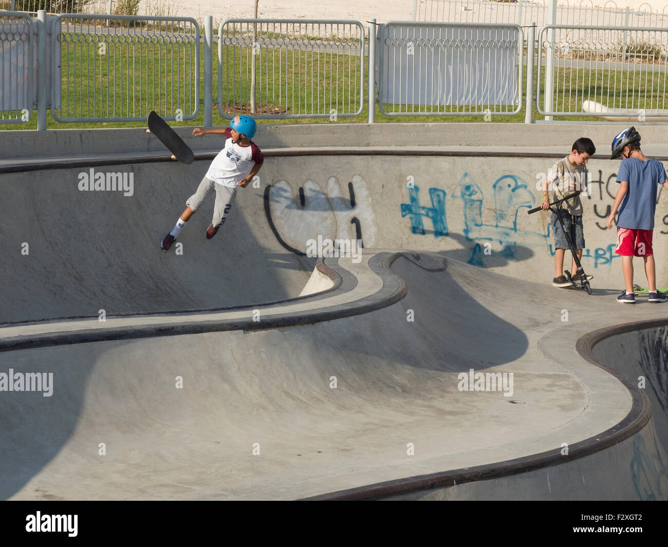 Urban extreme sport park. Young skateboarder performs stunts with a ...