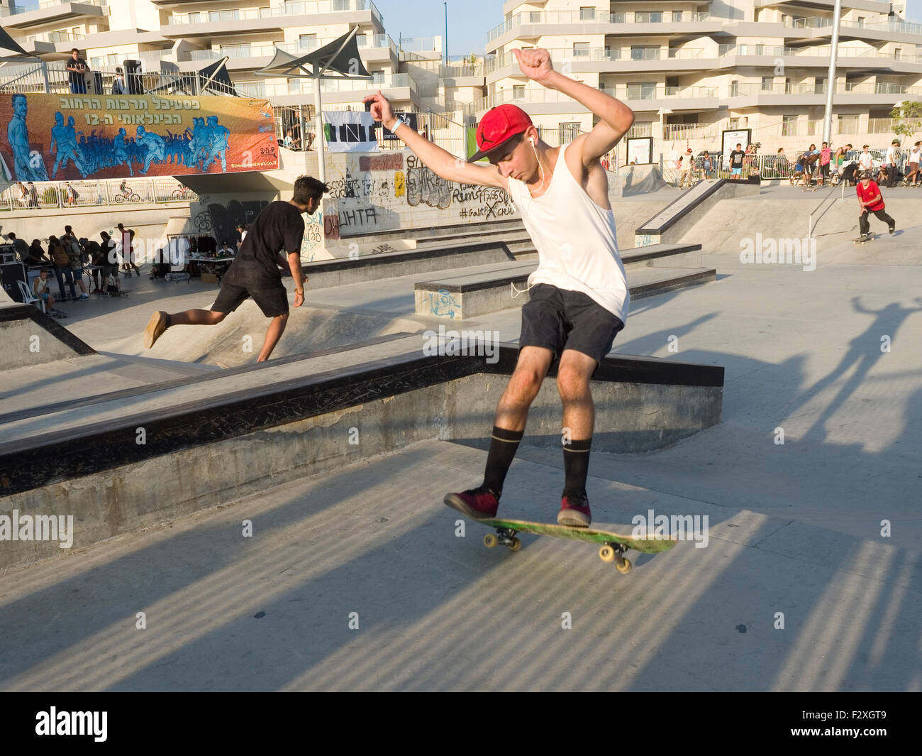 Urban extreme sport park. Young skateboarder performs stunts with a ...