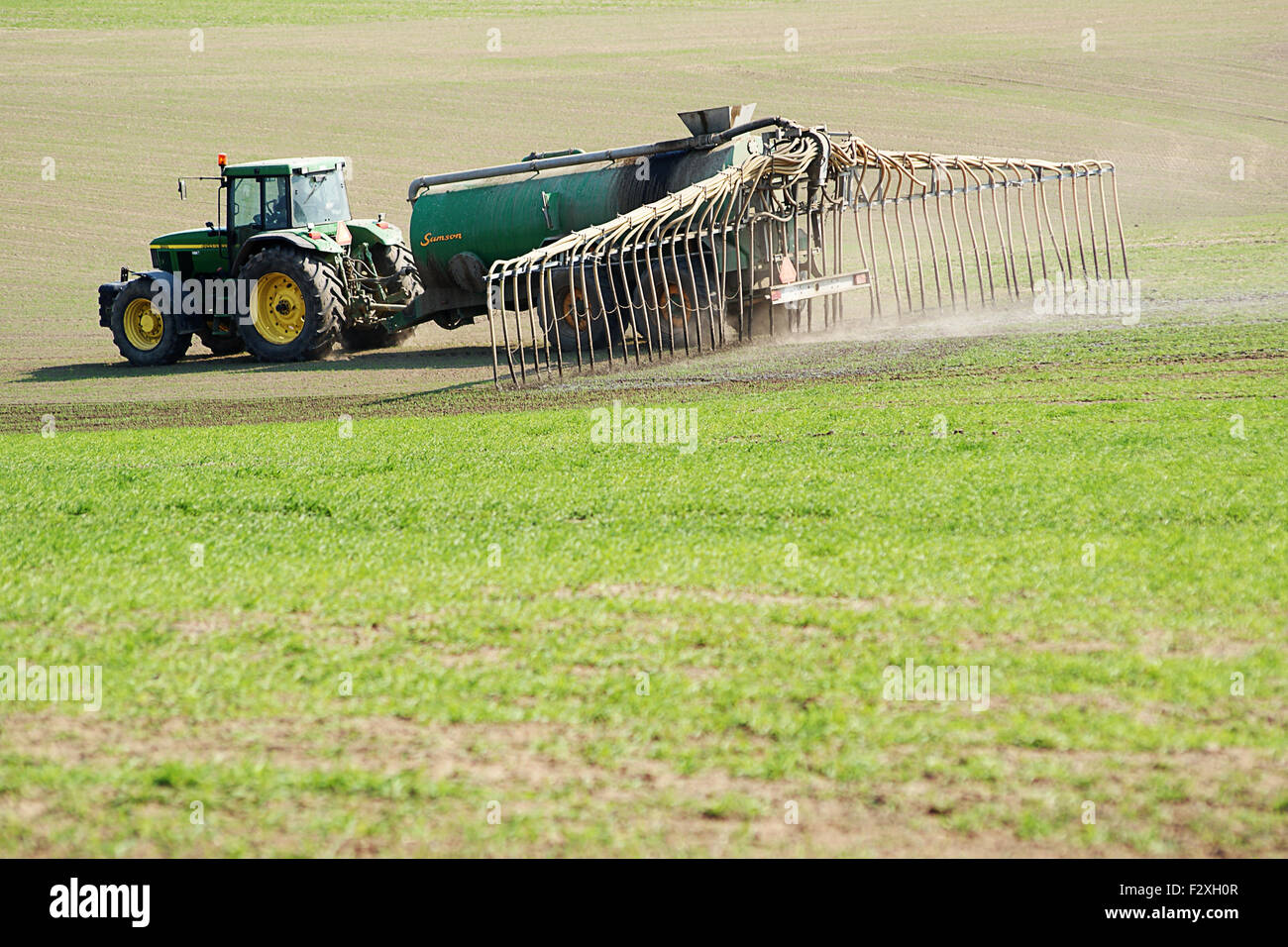 Fertilising, spreading manure by tractor over fields Stock Photo - Alamy