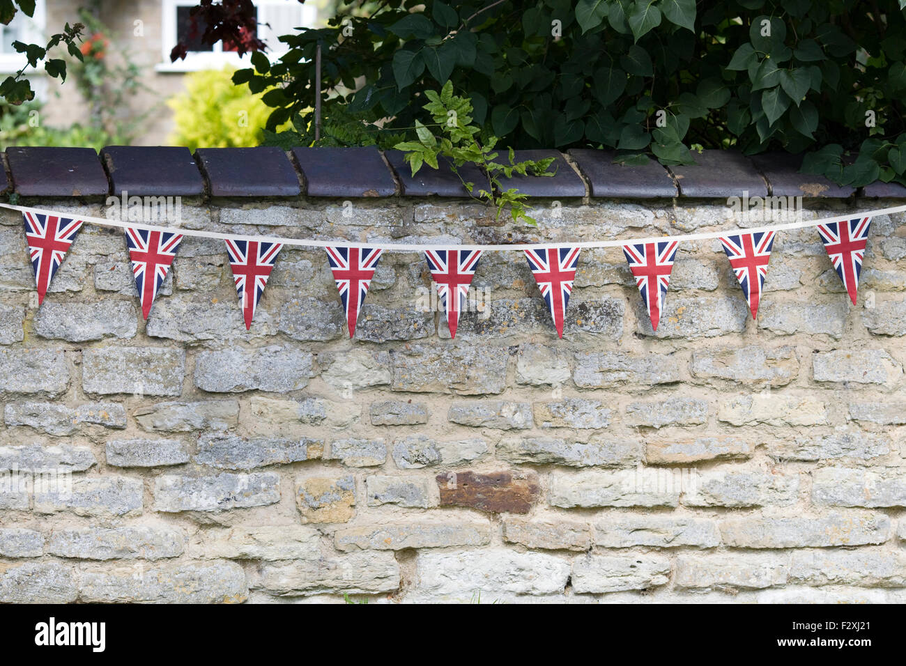 Union Jack Flag Bunting Hanging on a stone wall Stock Photo - Alamy