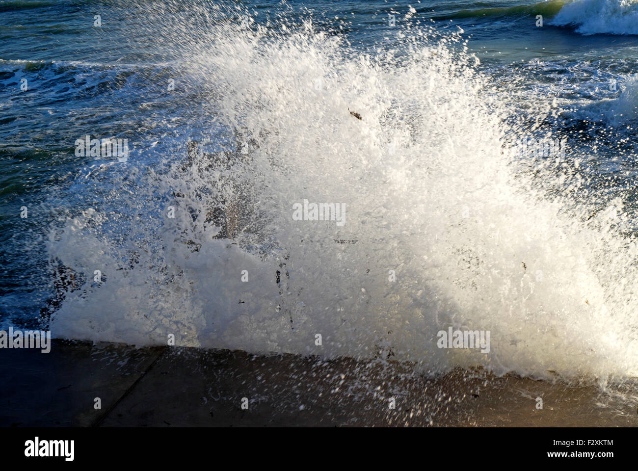 A wave buffeting the sea wall on the east coast at Bacton-on-Sea ...