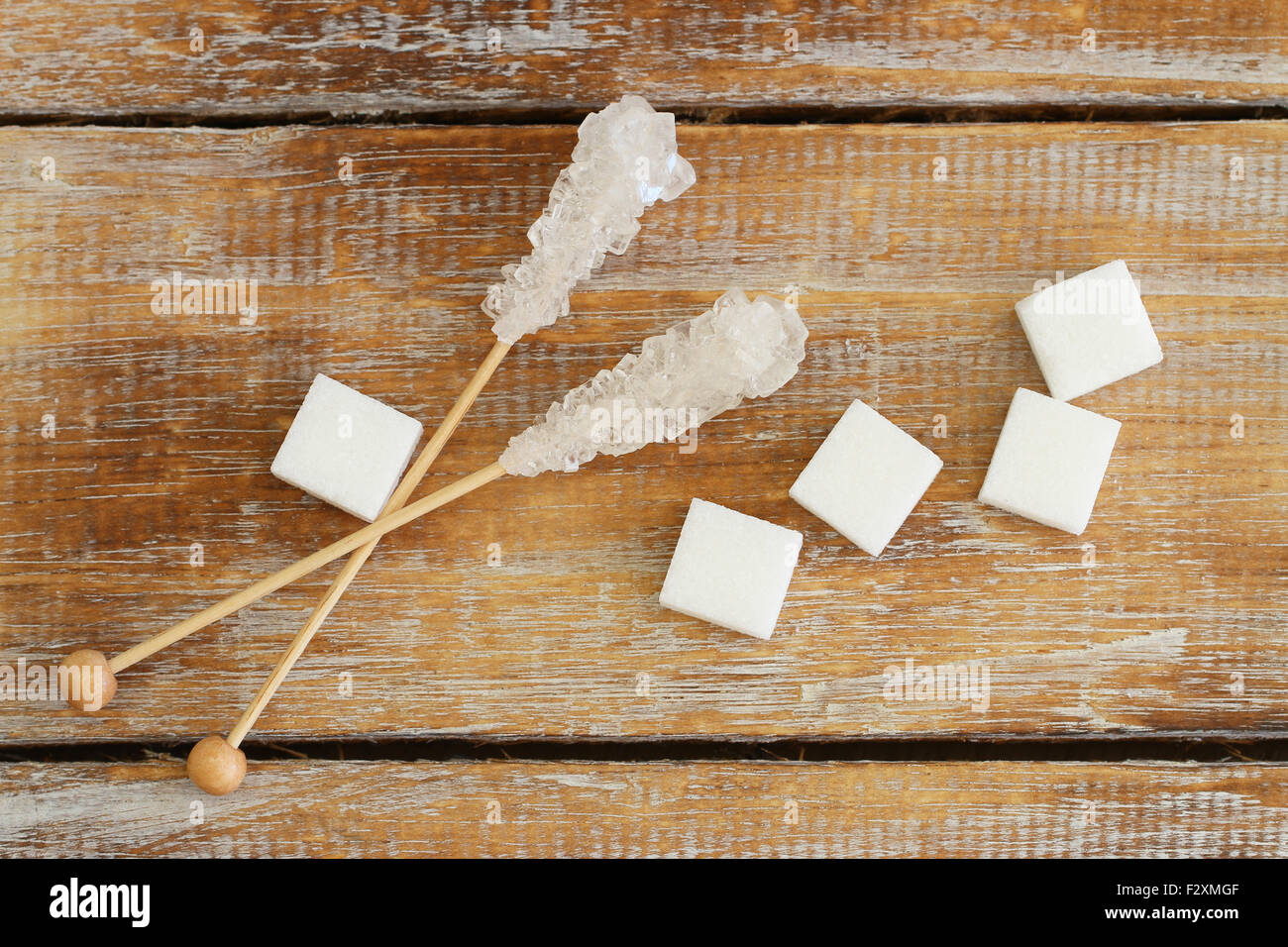 White sugar cubes and white sugar sticks on rustic wooden surface Stock ...