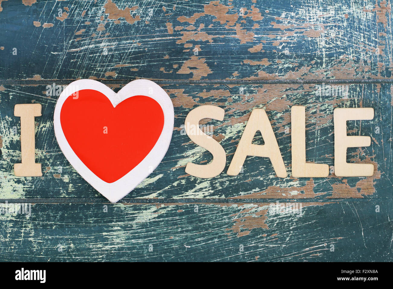 I love sale written on rustic wooden surface and white and red heart ...