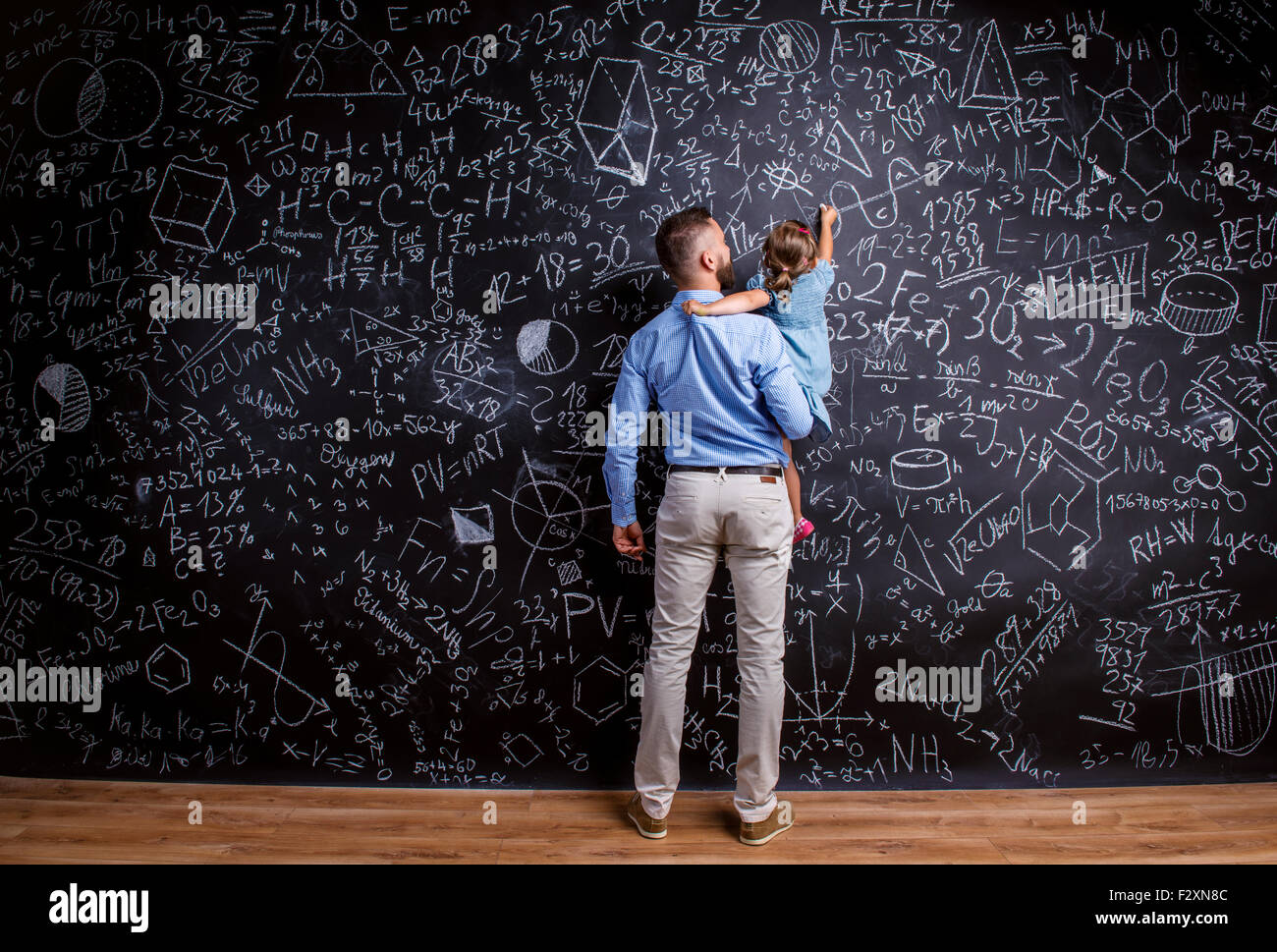 Young hipster school teacher with his pupil in front of big blackboard ...