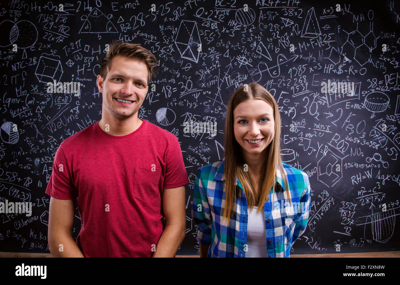 Beautiful young students in front of big blackboard Stock Photo - Alamy