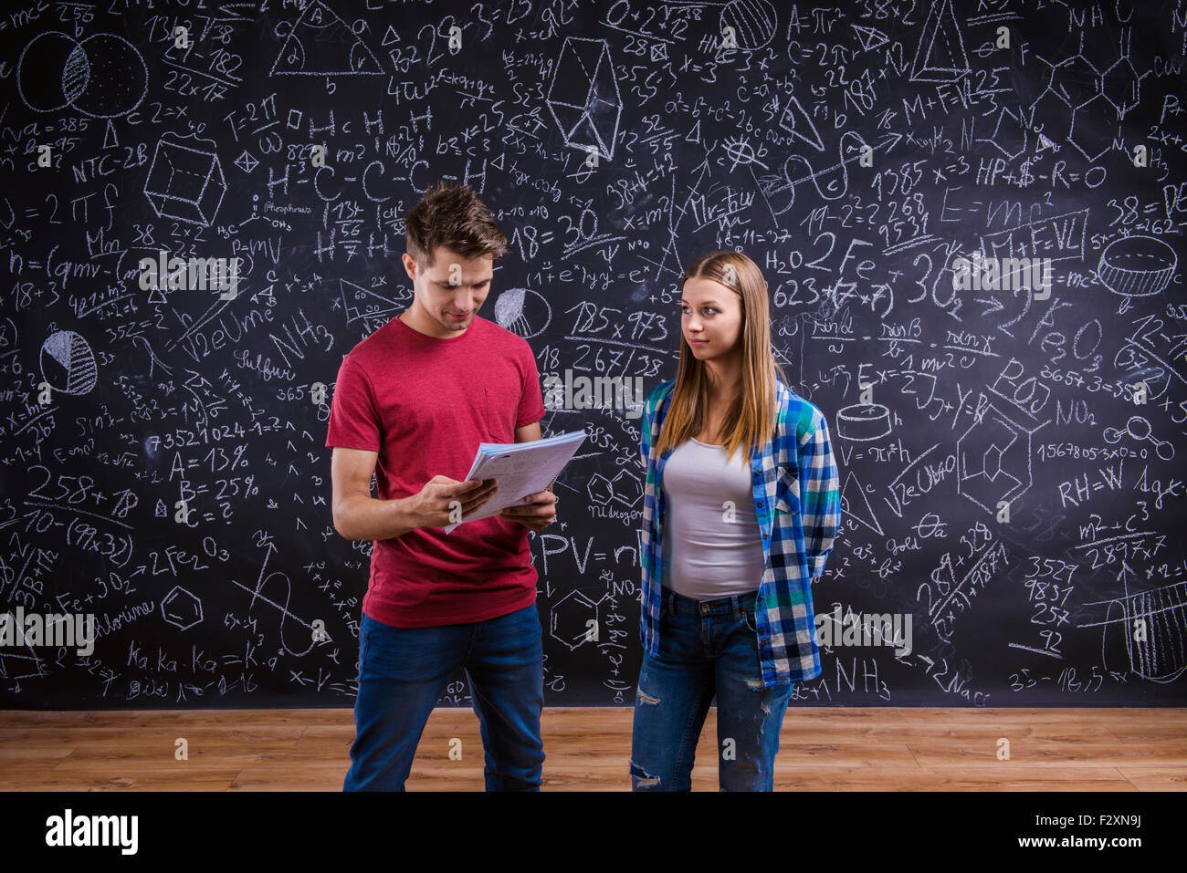 Beautiful young students in front of big blackboard Stock Photo - Alamy