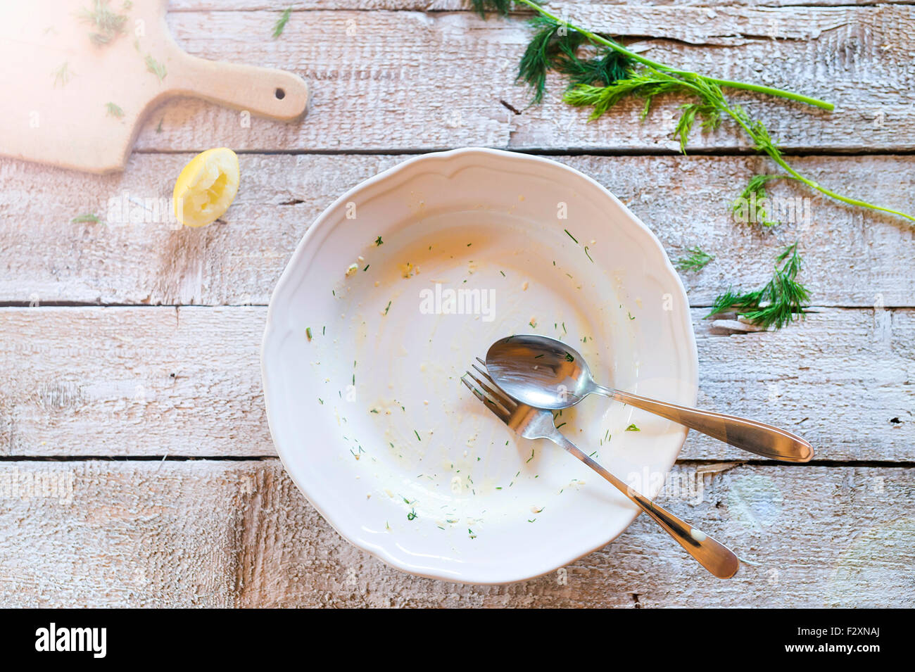 Empty plate after finishing salmon tagliatelle on wooden kitchen table ...