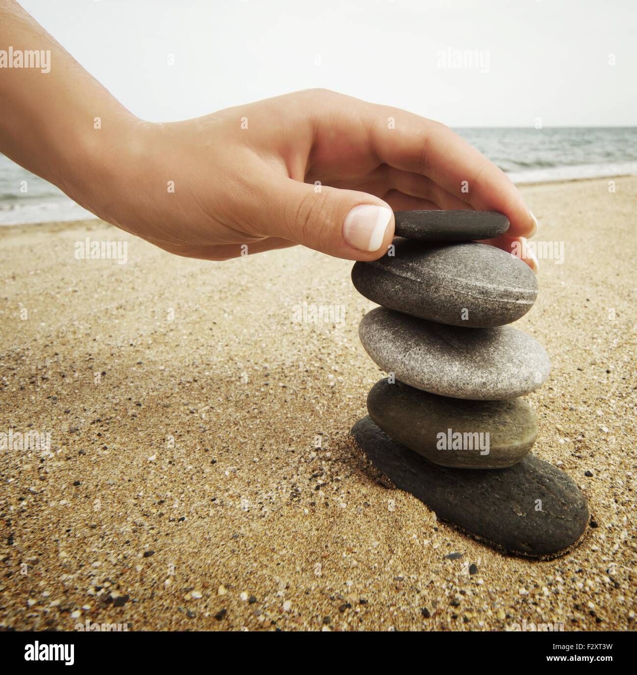 Woman hand touching stones on the beach Stock Photo - Alamy