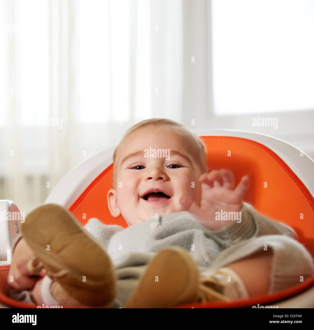 Happy child sitting on a chair Stock Photo - Alamy