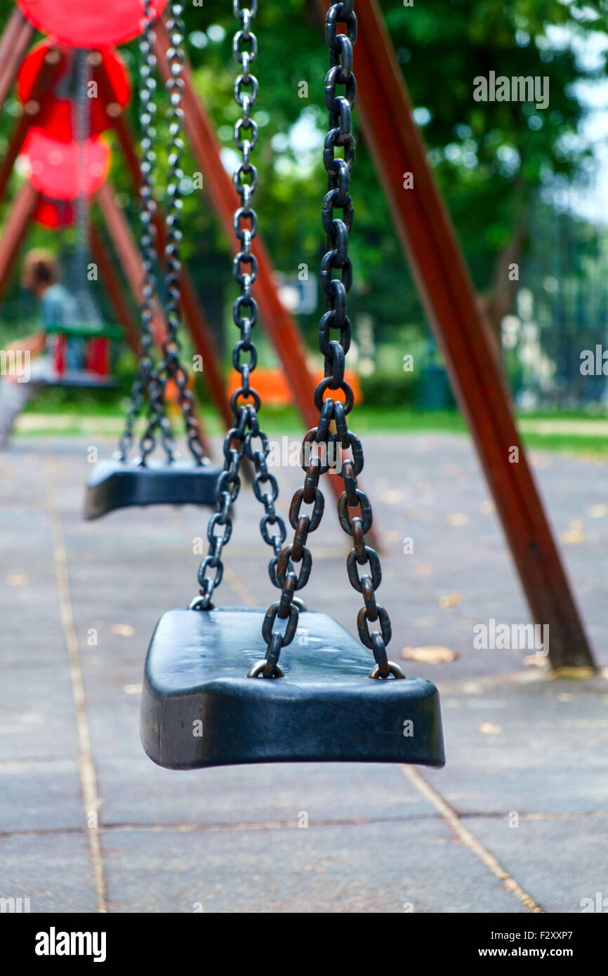 Empty chain swing in playground in city Stock Photo - Alamy
