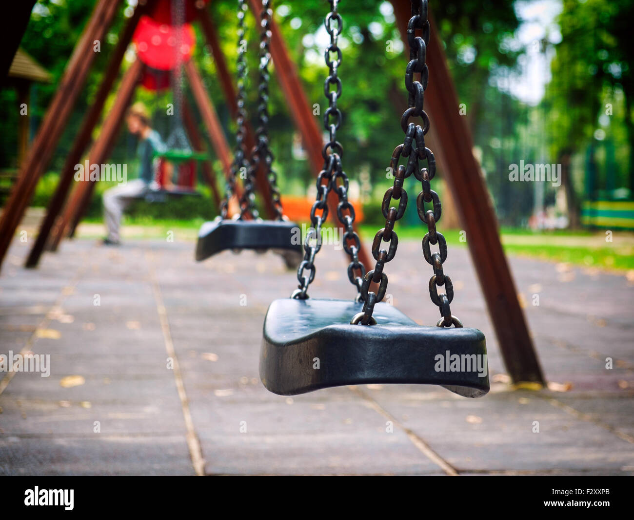 Empty chain swing in playground in city Stock Photo - Alamy