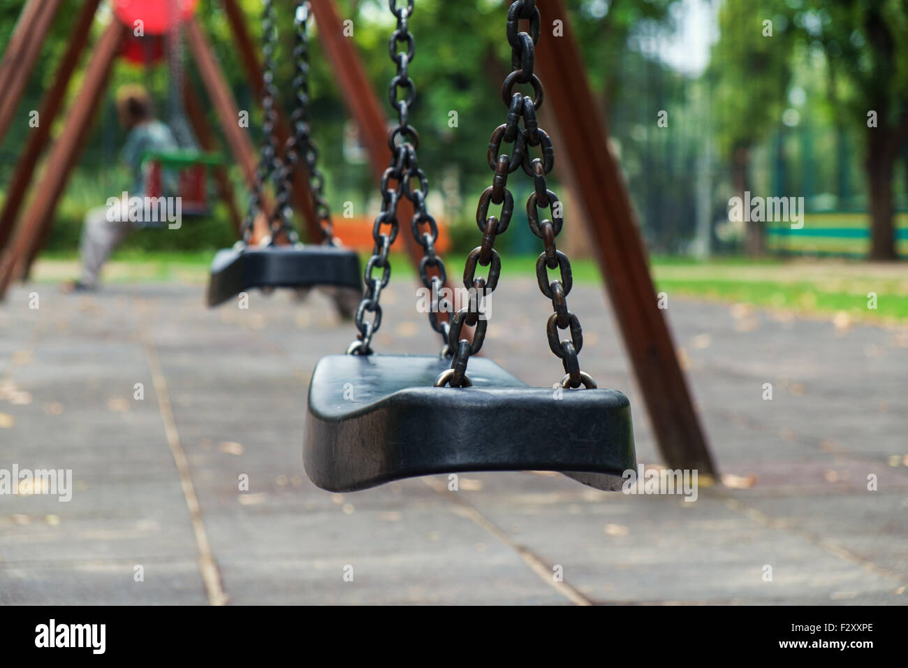 Empty chain swing in playground in city Stock Photo - Alamy