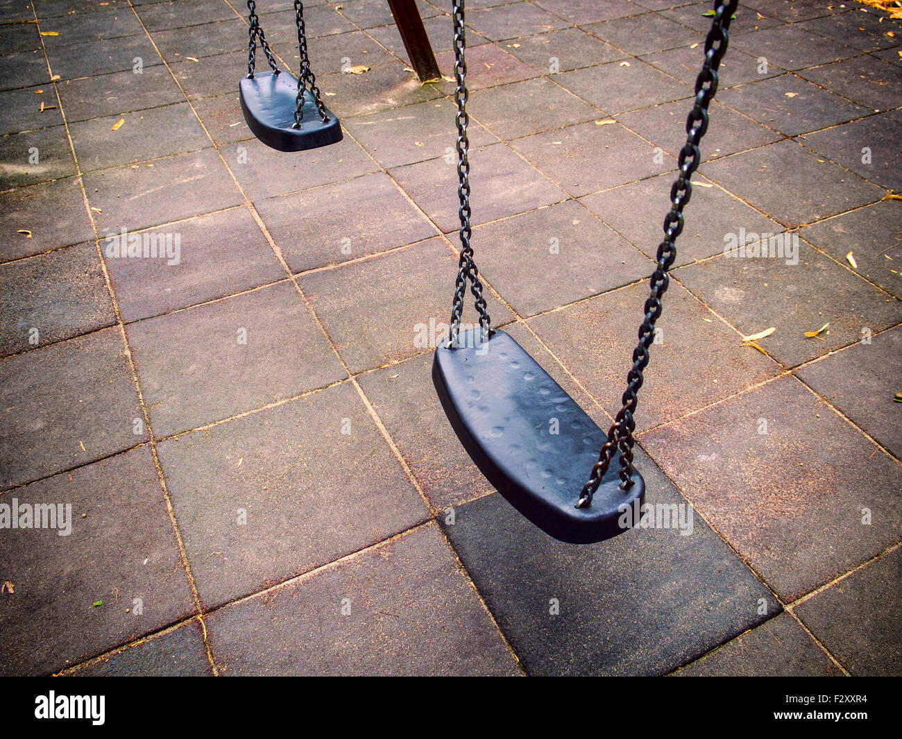Empty chain swing in playground in city Stock Photo - Alamy