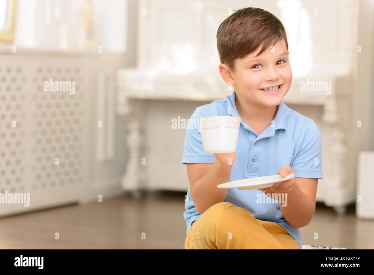 Joyful boy drinking tea Stock Photo - Alamy